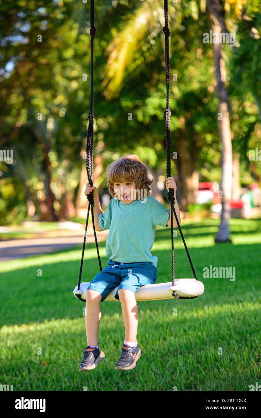 Little child having fun on a swing outdoor. Summer playground. Kid swinging high Stock Photo - Alamy