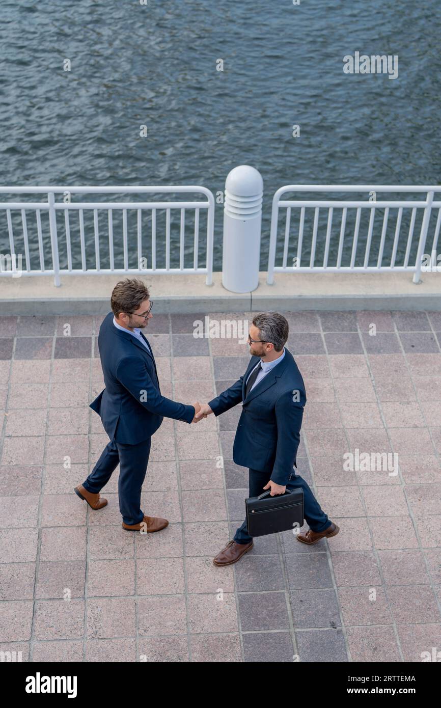 Business man shaking hands. Two businessmen handshake outdoor ...