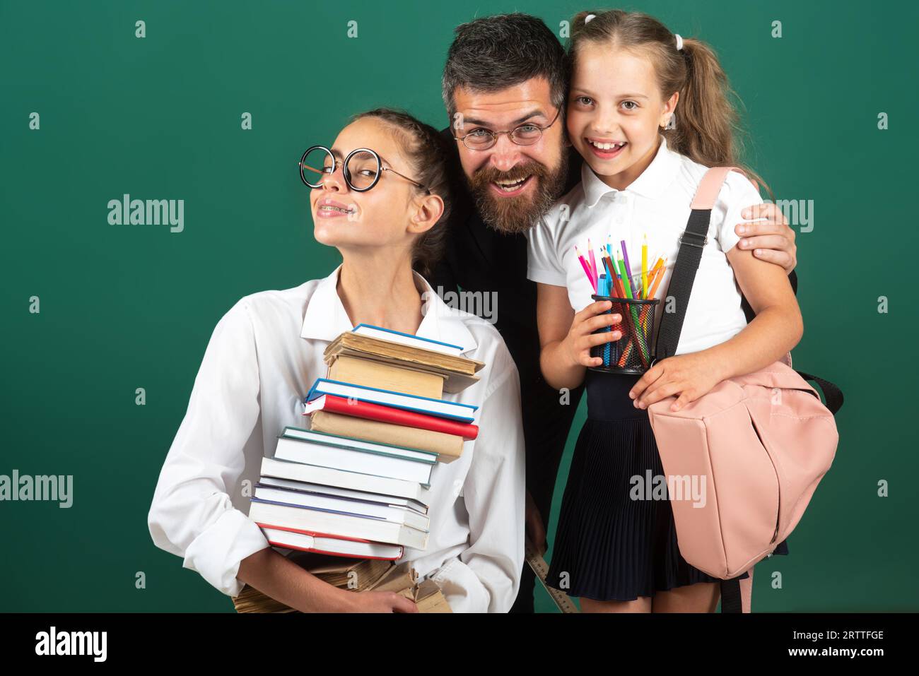 Elementary pupil with teacher in studio, isolated. Smiling male teacher ...
