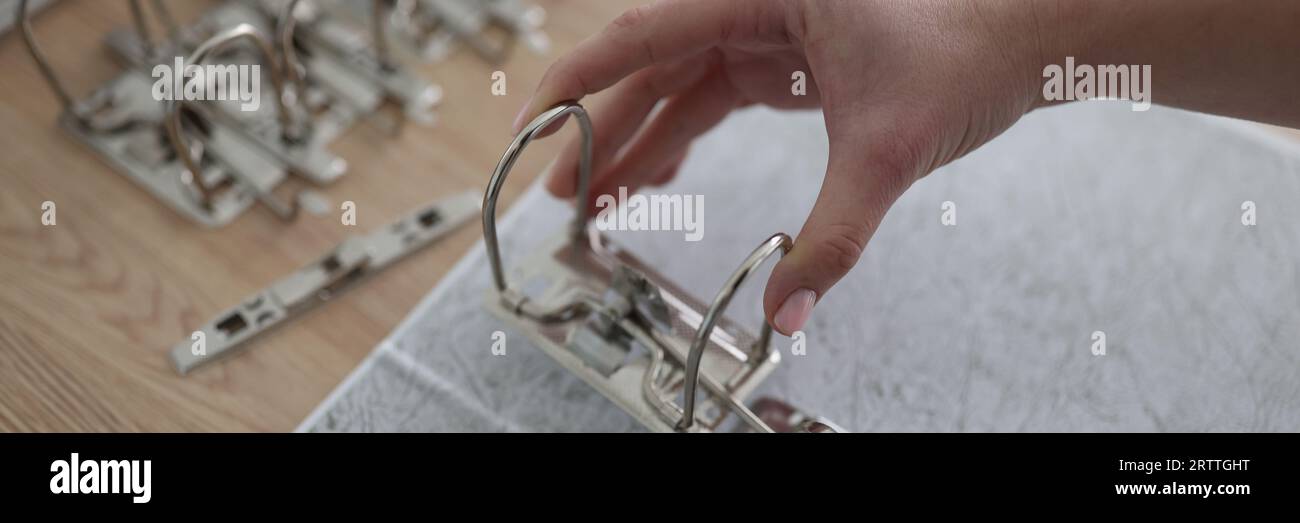 Secretary attaching metal bindings to office folders Stock Photo - Alamy