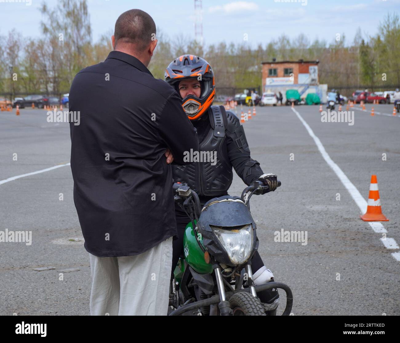 A young woman is learning to ride a motorbike in a motorcycle school ...