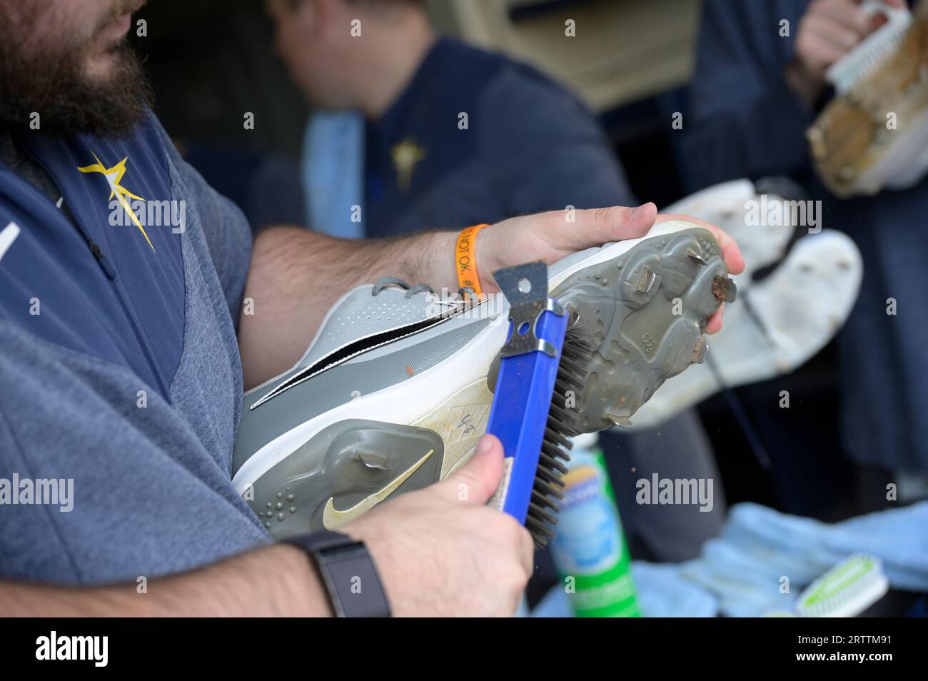 Team staff members clean the cleats of Tampa Bay Rays players in the ...