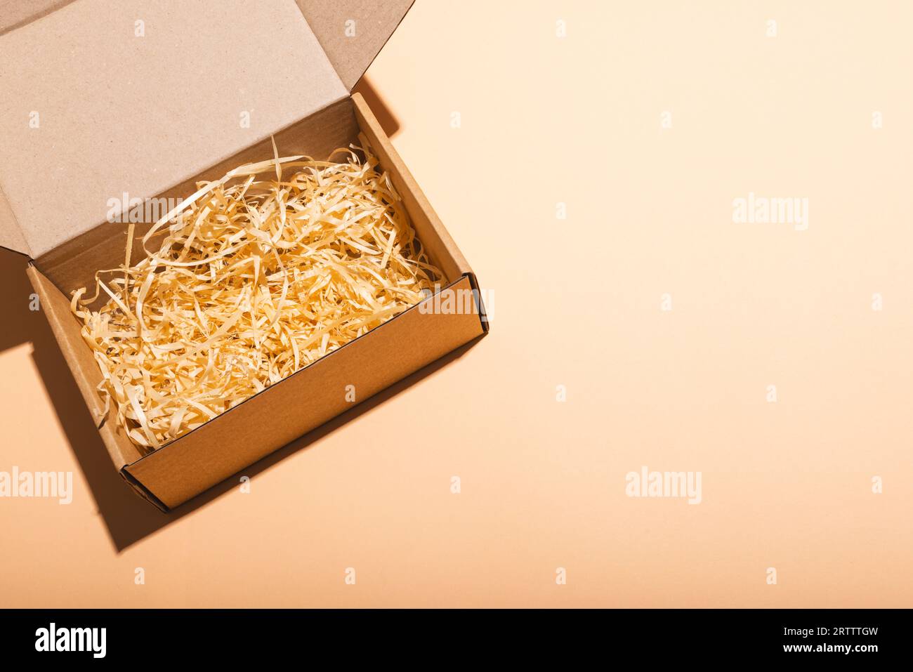 Open box with straw lining and copy space over cream background Stock ...