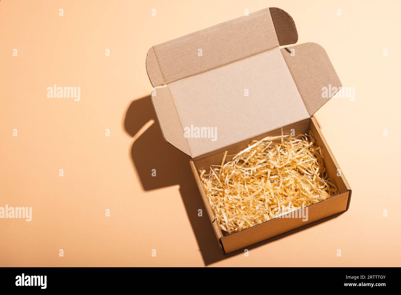 Open box with straw lining and copy space over cream background Stock ...