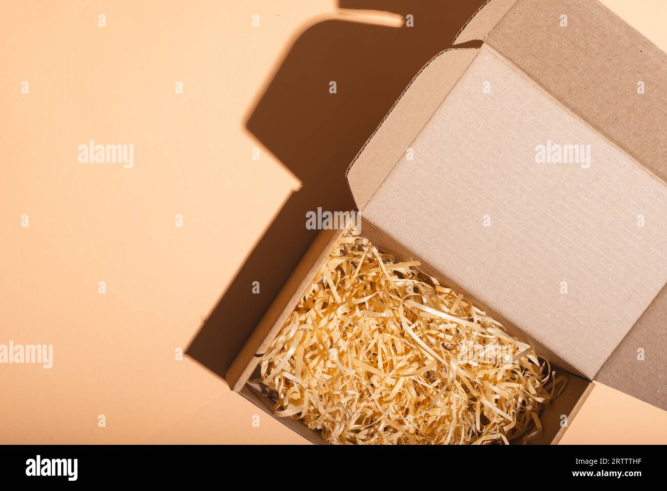 Open box with straw lining and copy space over cream background Stock ...
