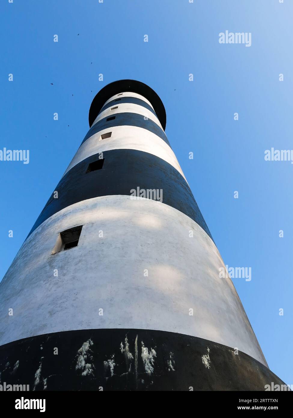 Tall black and white striped lighthouse on blue sky background Stock ...