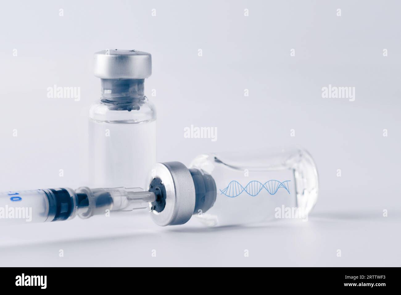 Glass vial and syringe with injection over white background ...