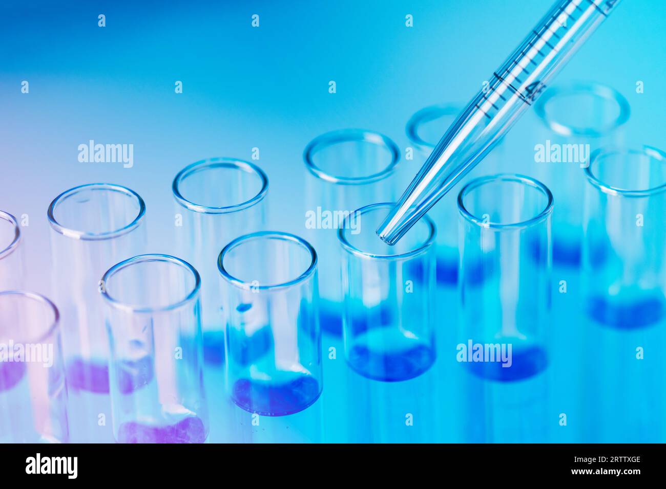 Test tubes with blue liquid water samples and pipette over blue ...