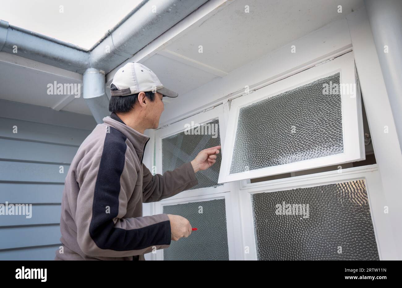 Worker preparing to replace the broken window glass. Home maintenance ...