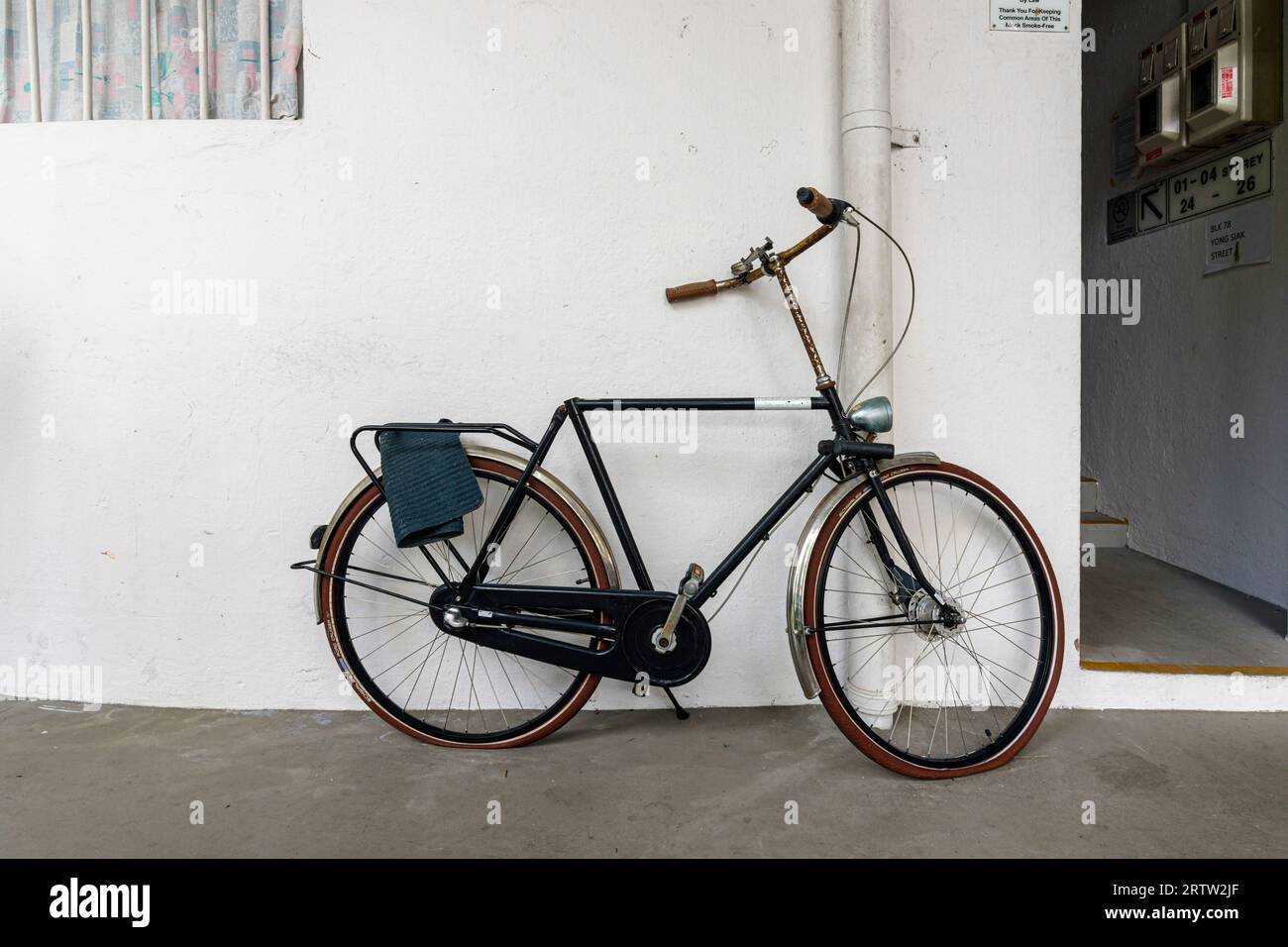 Urban detail of a bike without saddle leaning against a wall in the ...