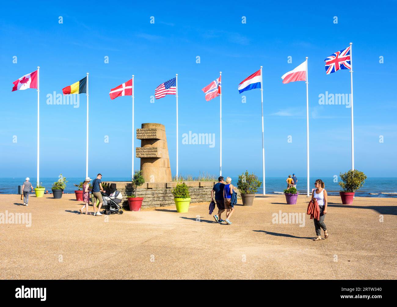Tourists stroll around the Signal monument in Bernières-sur-Mer, France ...