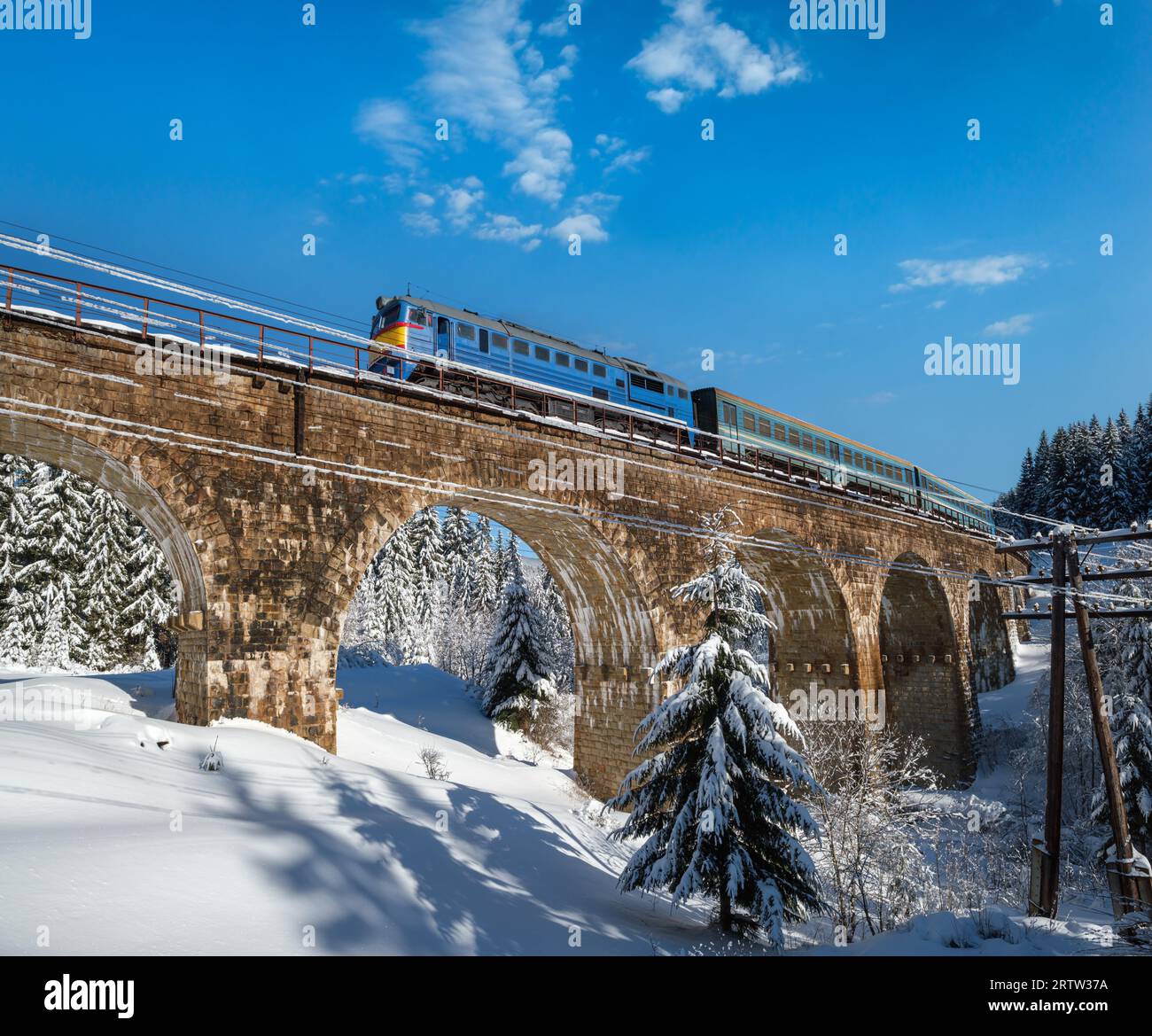 Stone viaduct (arch bridge) on railway through mountain snowy fir ...