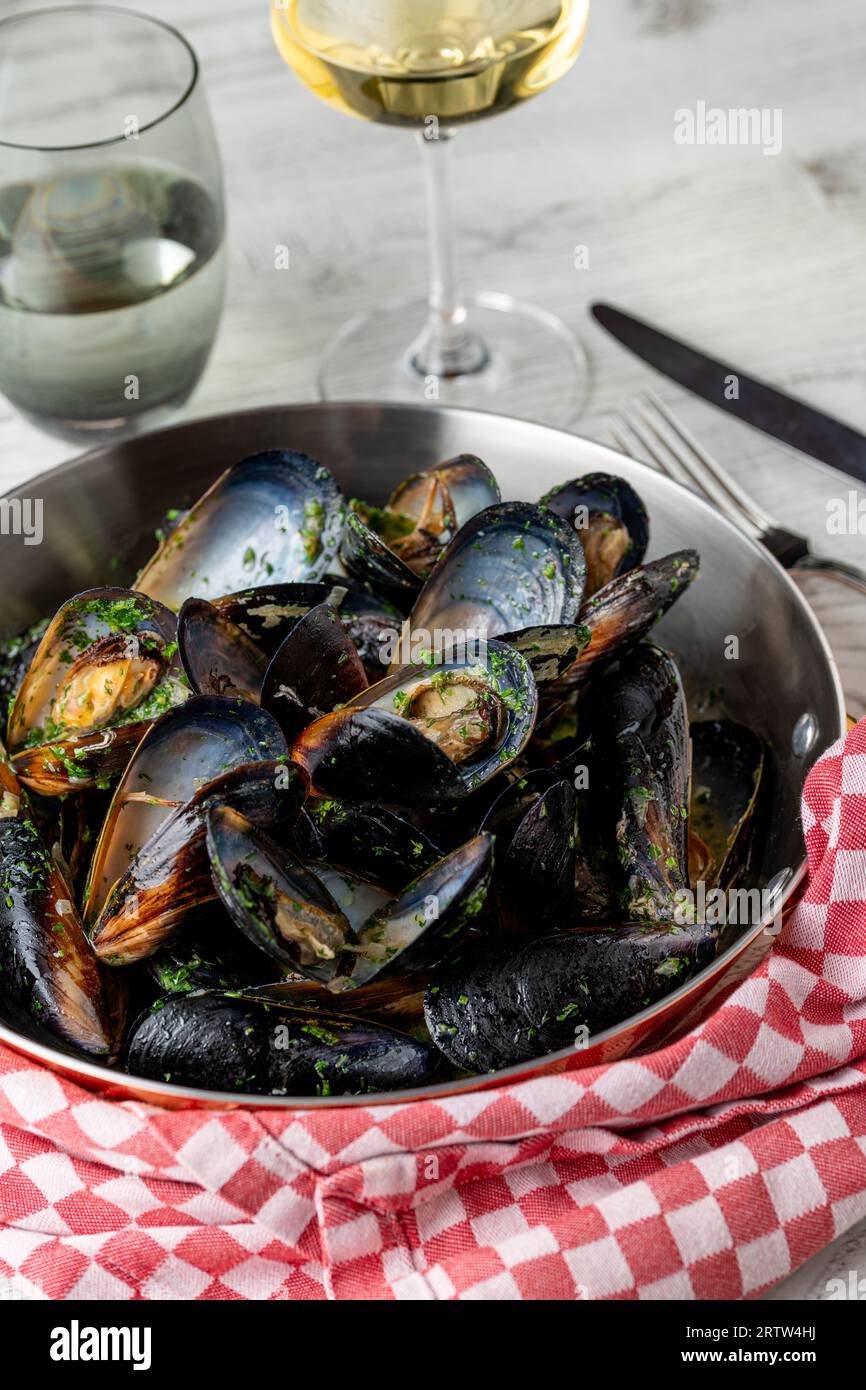 Baked blue mussels in spicy with lemon in a black cast-iron pot Stock ...