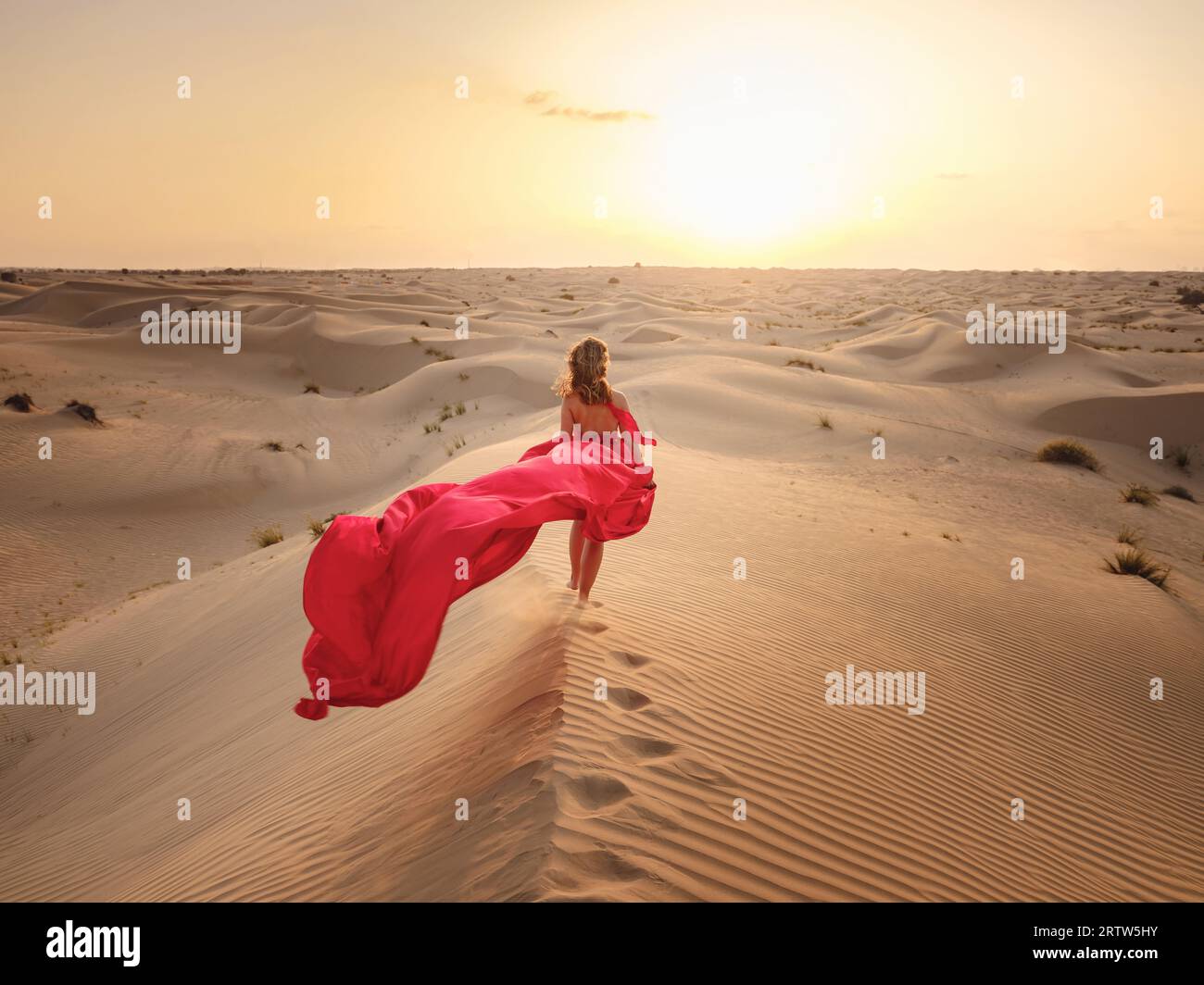 Desert adventure. Young arabian Woman in red silk dress in sands dunes ...