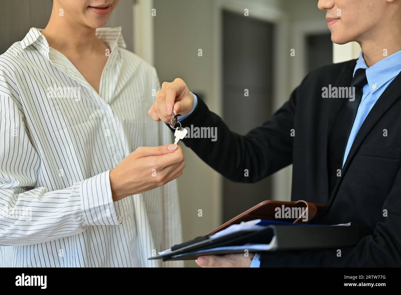 Smiling male buyer receiving keys from real estate agent. Real estate ...