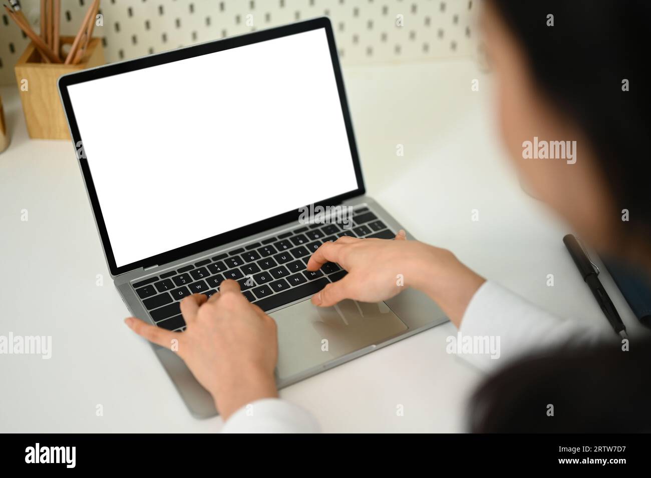 View over shoulder view of young woman hands typing on laptop keyboard ...