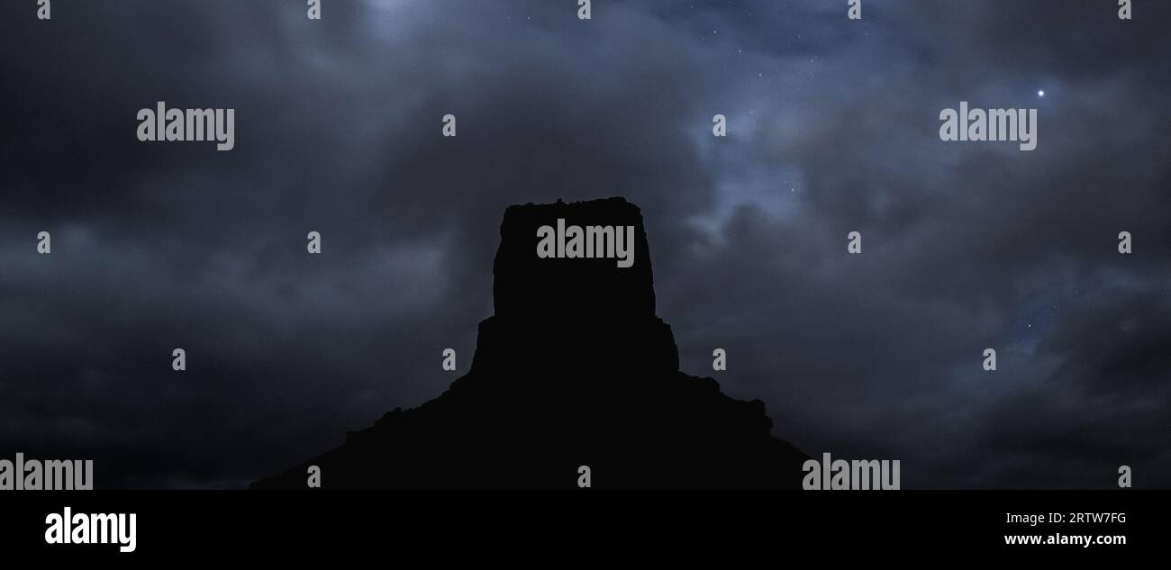 Castle Butte, in the Valley of the Gods, stands in silhouette against a ...
