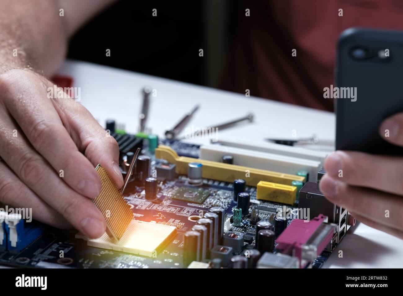 A technician repairs a motherboard in a service center. Computer Repair ...