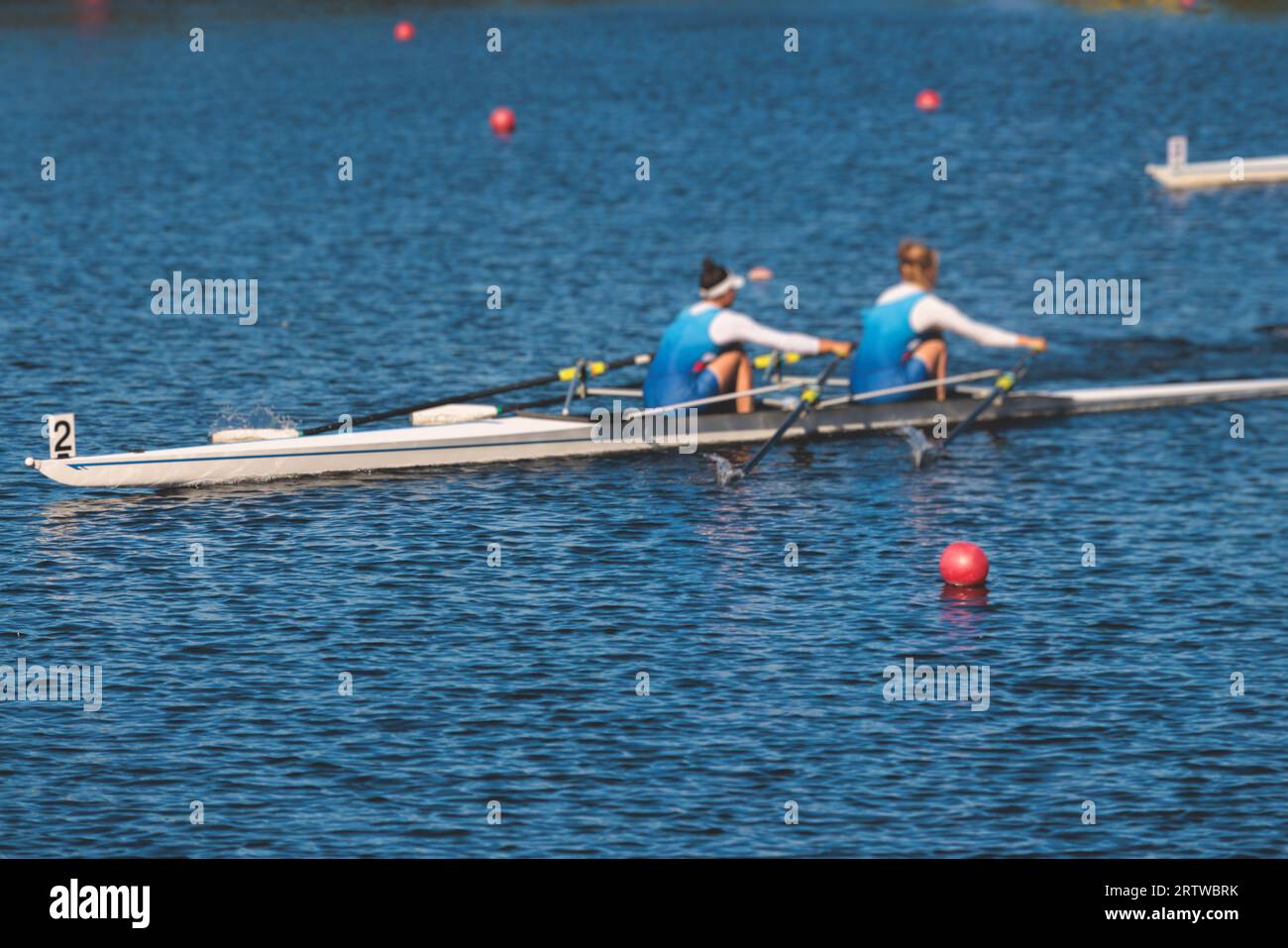 Group of rowing team female girl athletes sculling during competition ...