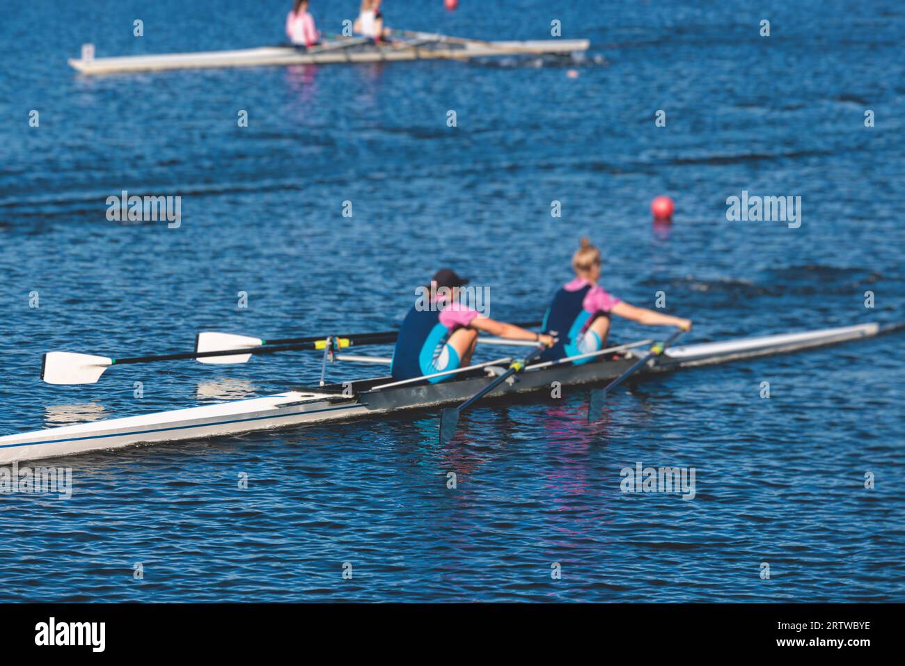 Group of rowing team female girl athletes sculling during competition ...