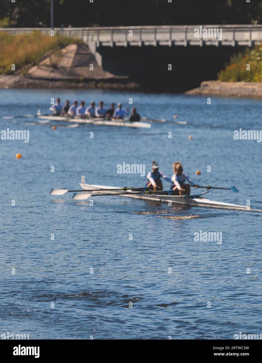 Group of rowing team athletes sculling during competition, kayak boats ...