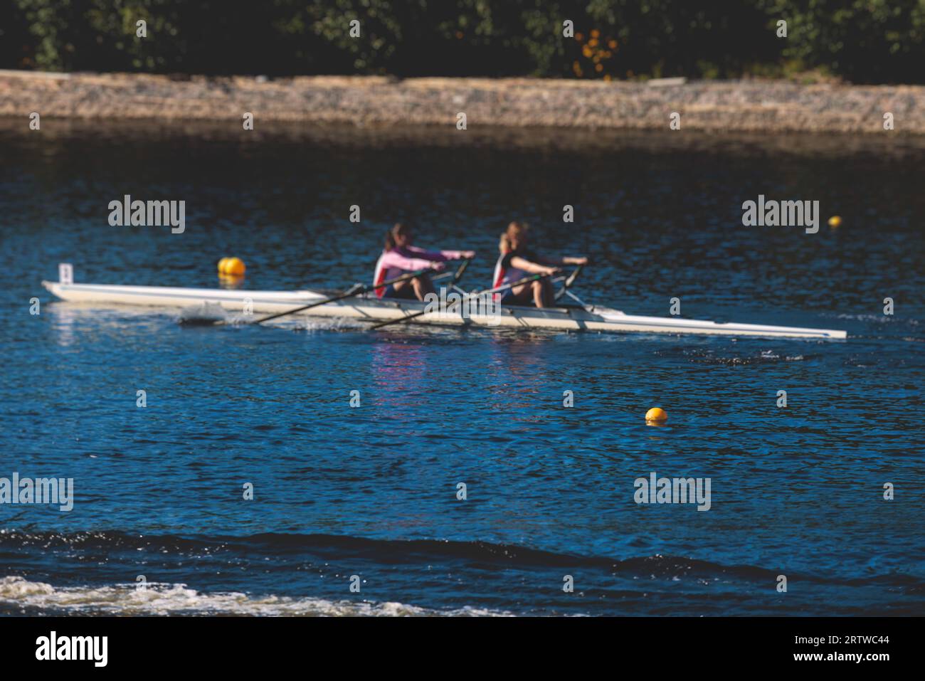Group of rowing team female girl athletes sculling during competition ...