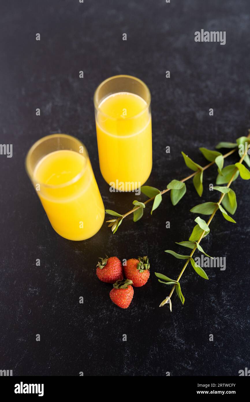 Two mimosas with strawberry garnish Stock Photo - Alamy