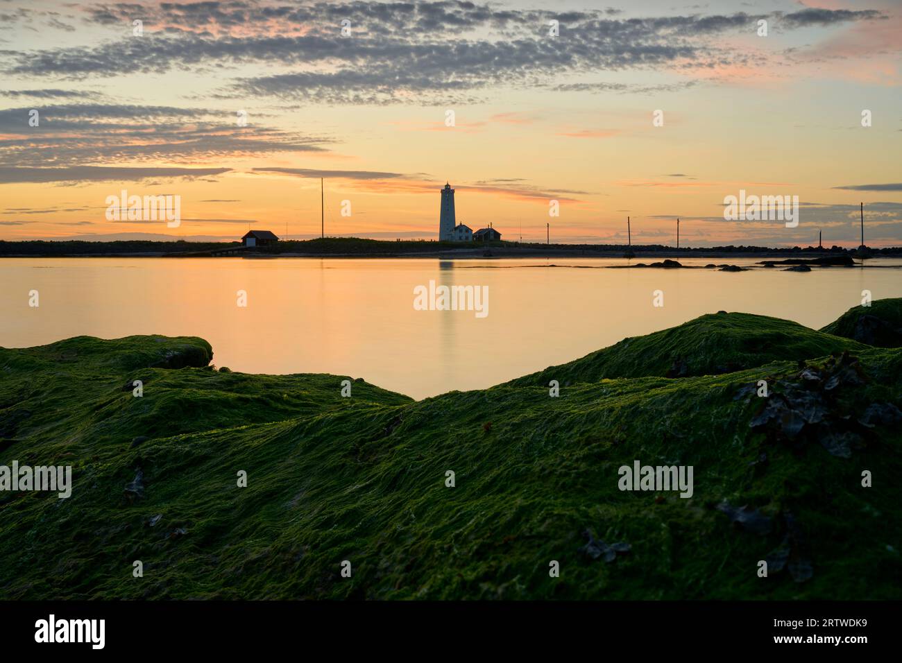 Amazing view of lighthouse with shadow on water in sundown time Stock ...
