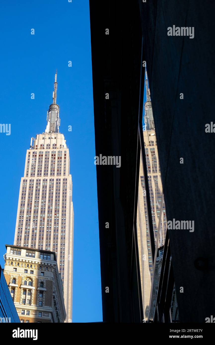 Empire State Building reflected in building window vertical Stock Photo ...