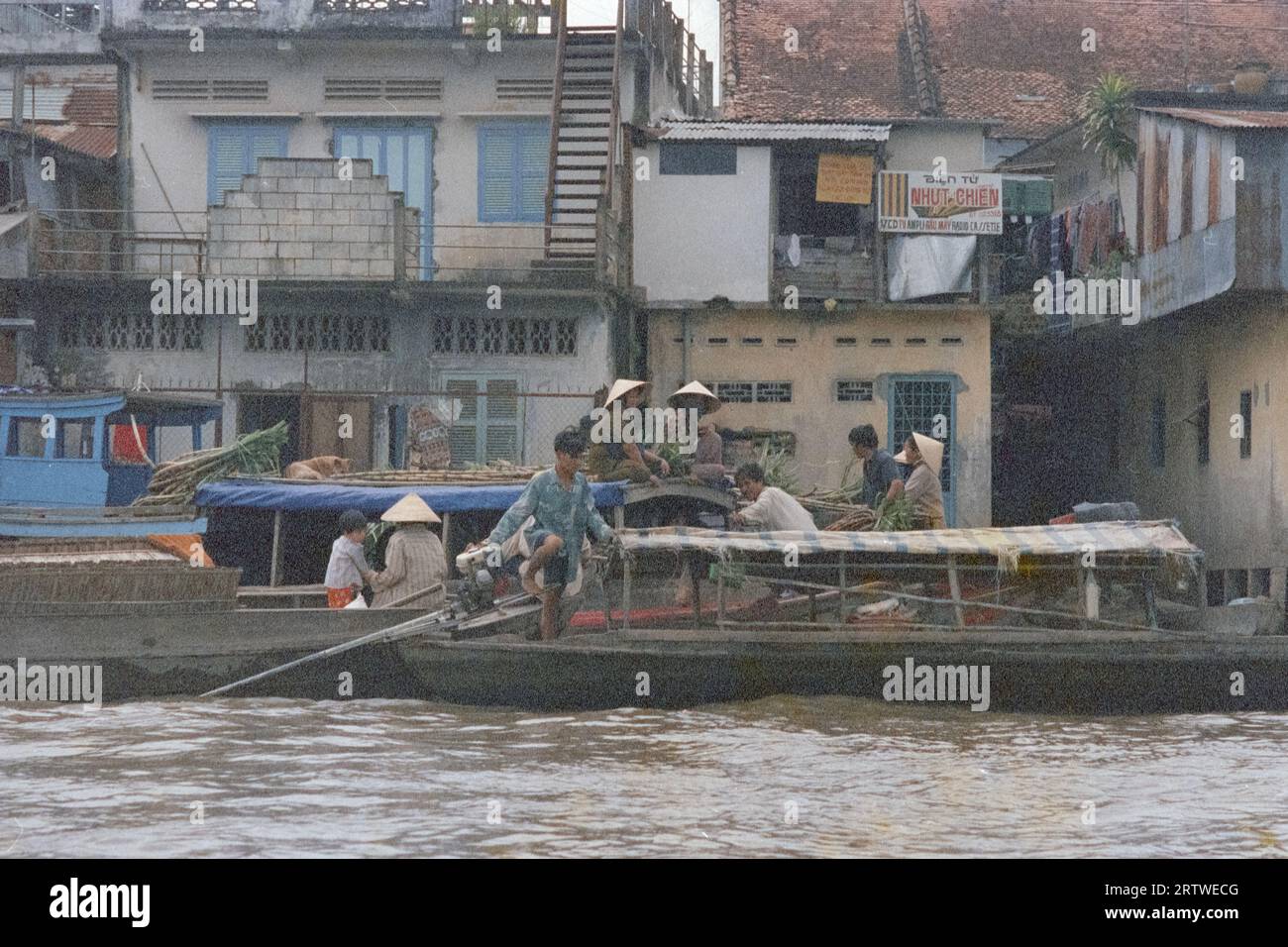 Vietnamese merchants transporting goods in a boat on the Mekong river ...