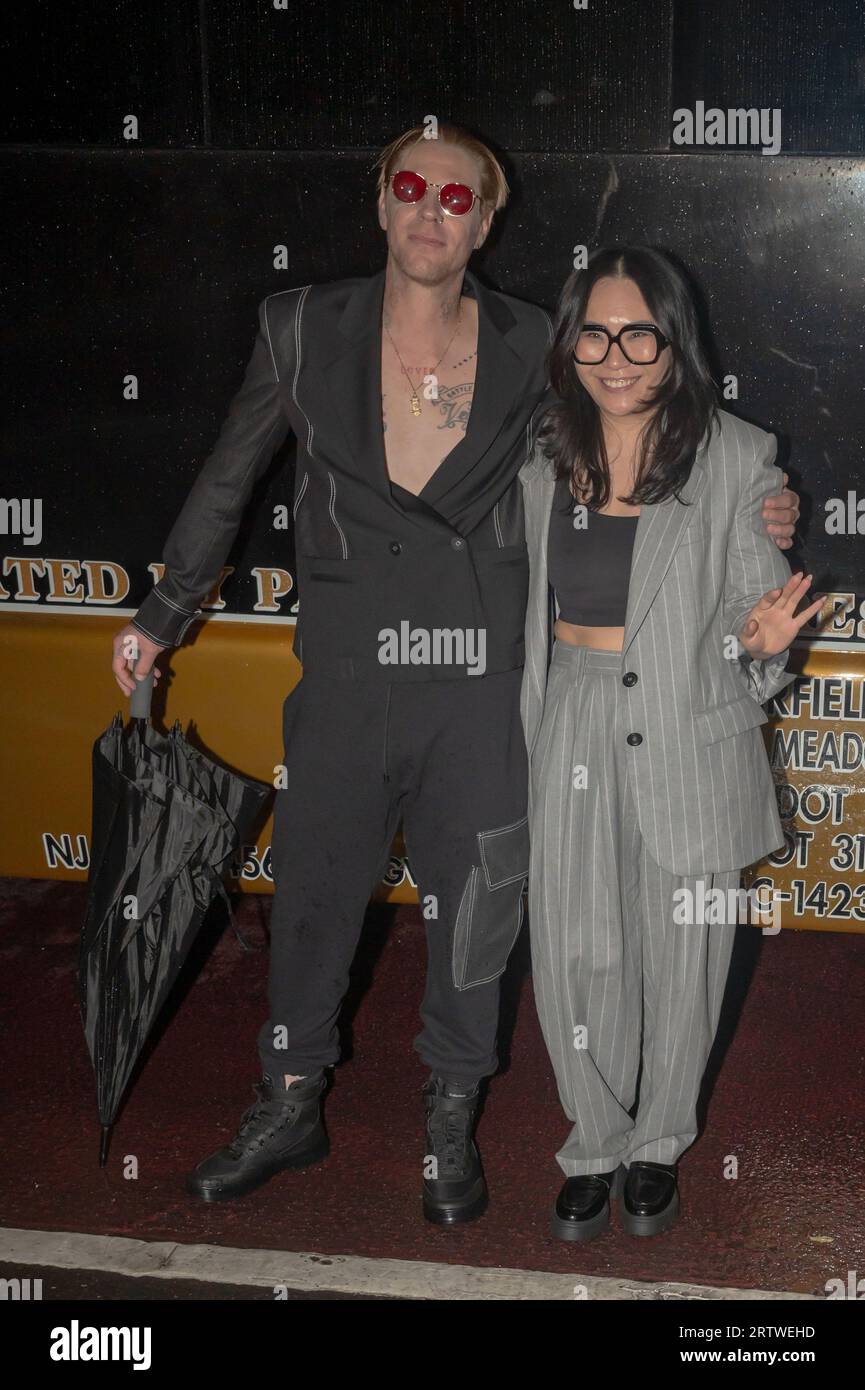 A model and Designer Shao Yang pose on the street during the arrivals ...