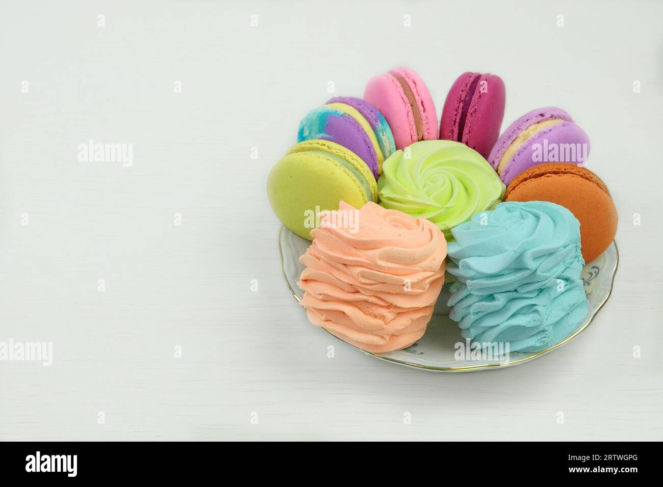 Various desserts. Macaroons, marshmallows and zephyrs in plate on a ...