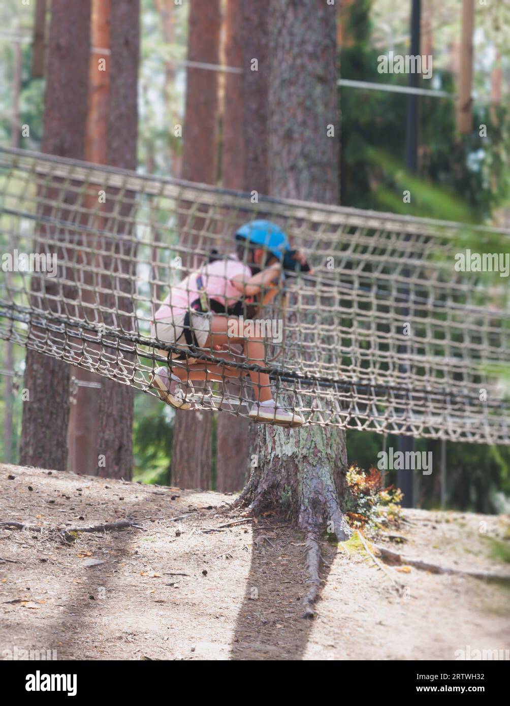 View of high ropes course, kids of climbing in amusement acitivity rope ...