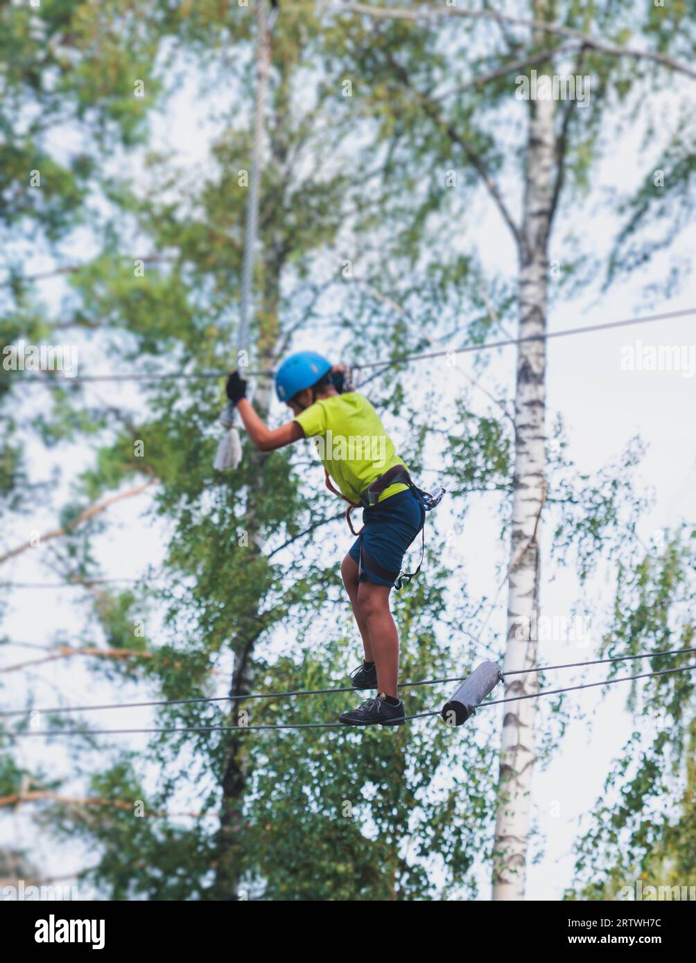 View of high ropes course, kids of climbing in amusement acitivity rope ...