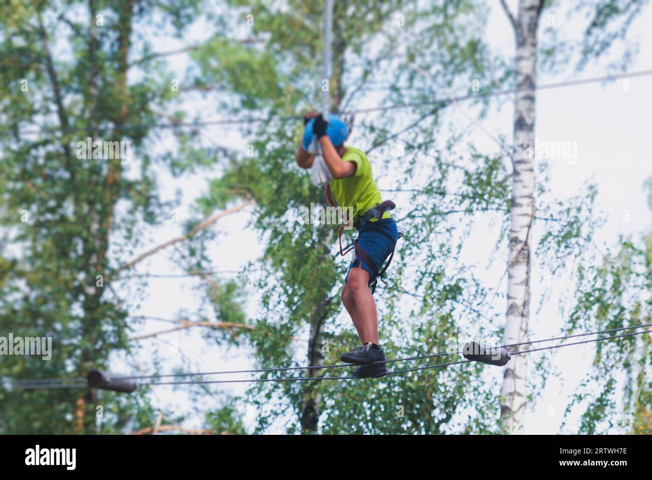 View of high ropes course, kids of climbing in amusement acitivity rope ...