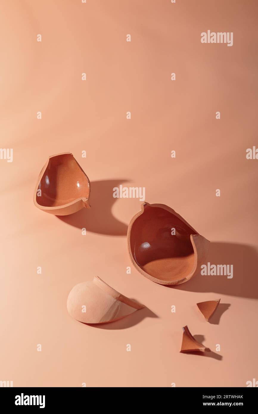 Details of broken ceramic cup on beige background Stock Photo - Alamy