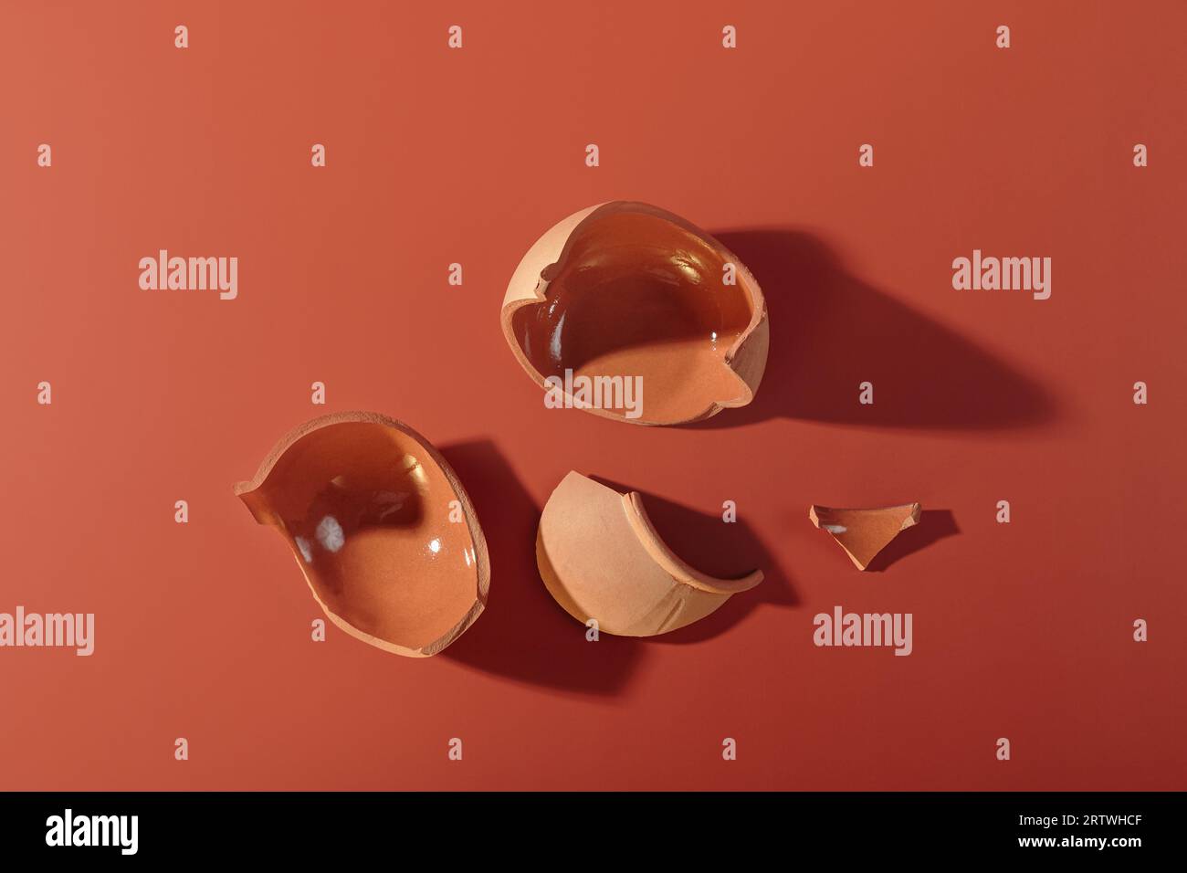 Details of broken ceramic cup on red background Stock Photo - Alamy