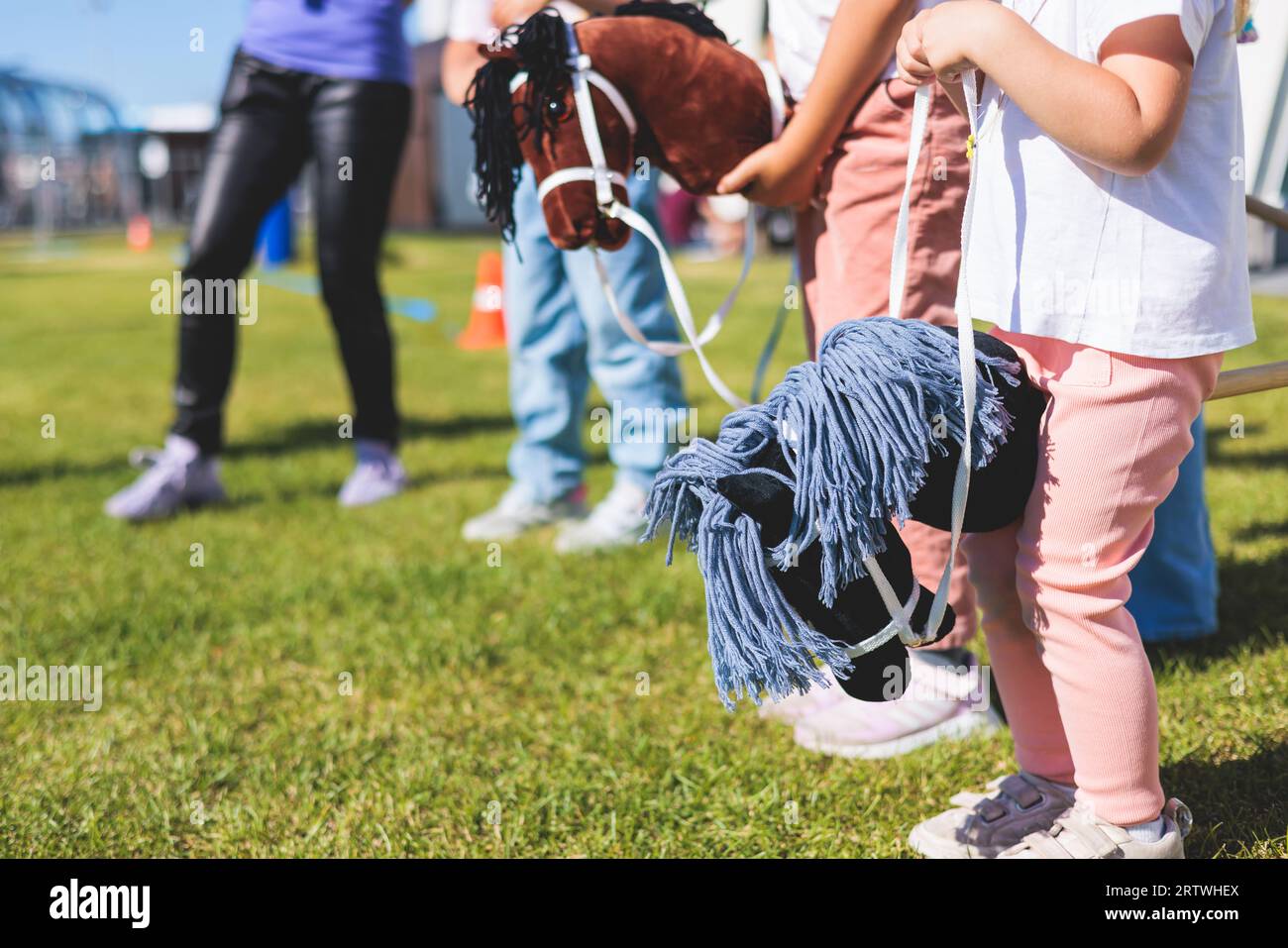 Hobby horsing competition on a green grass, hobby horse riders jumping ...