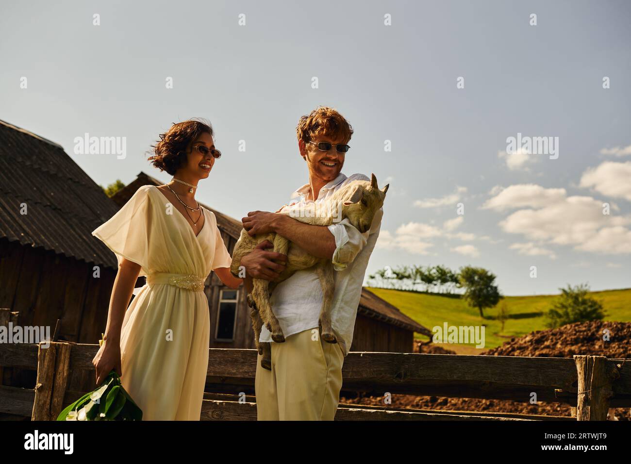 rustic wedding in style of boho, happy man holding baby goat near asian ...