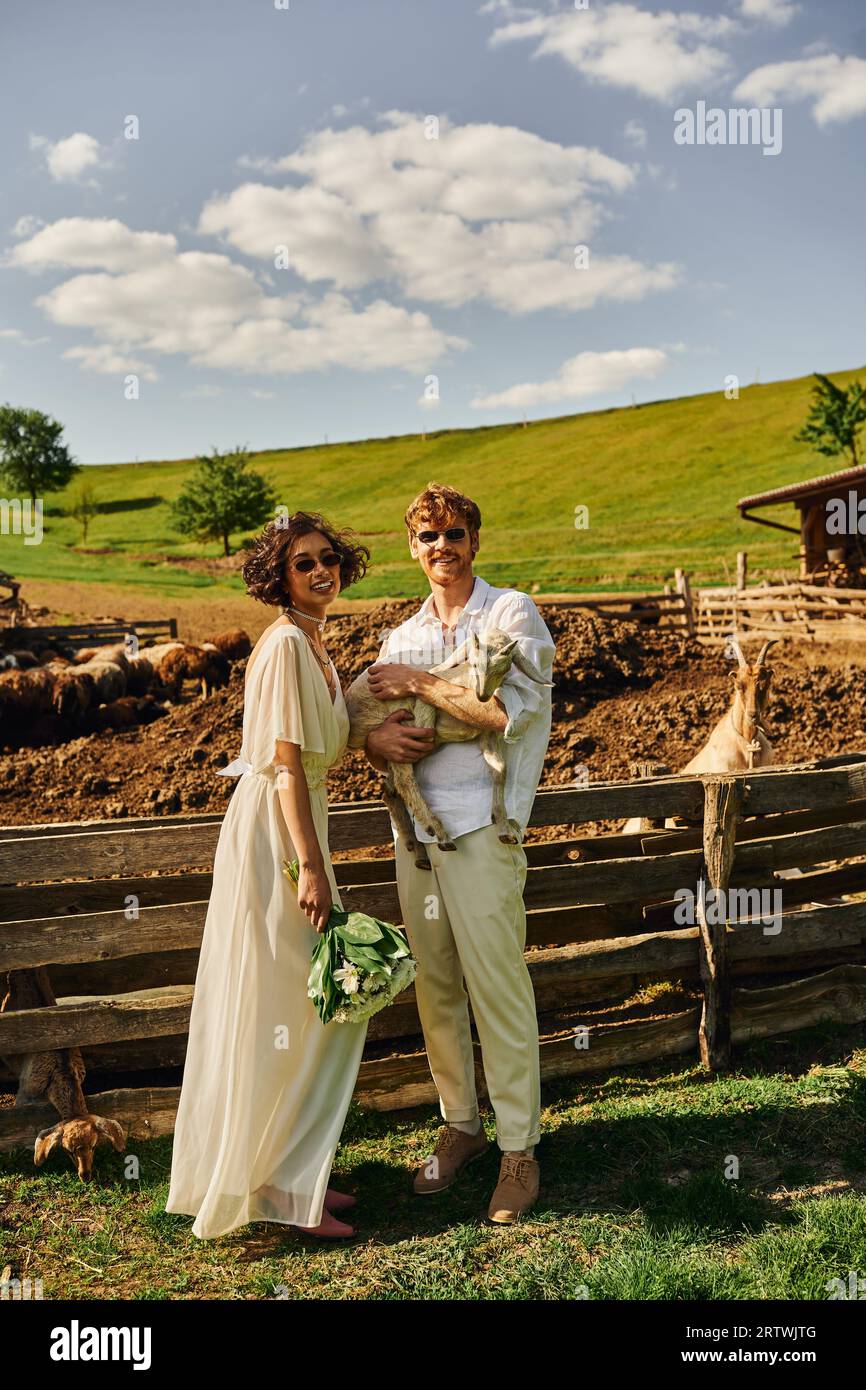 rustic wedding in boho style, happy groom holding baby goat near asian ...