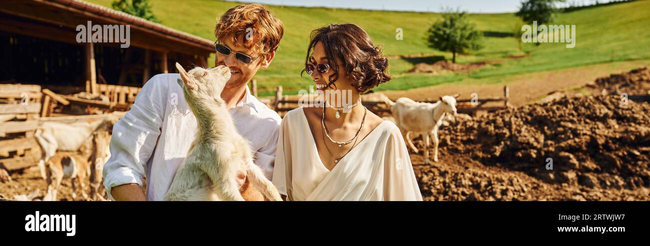 just married couple, groom holding baby goat near asian bride in white ...