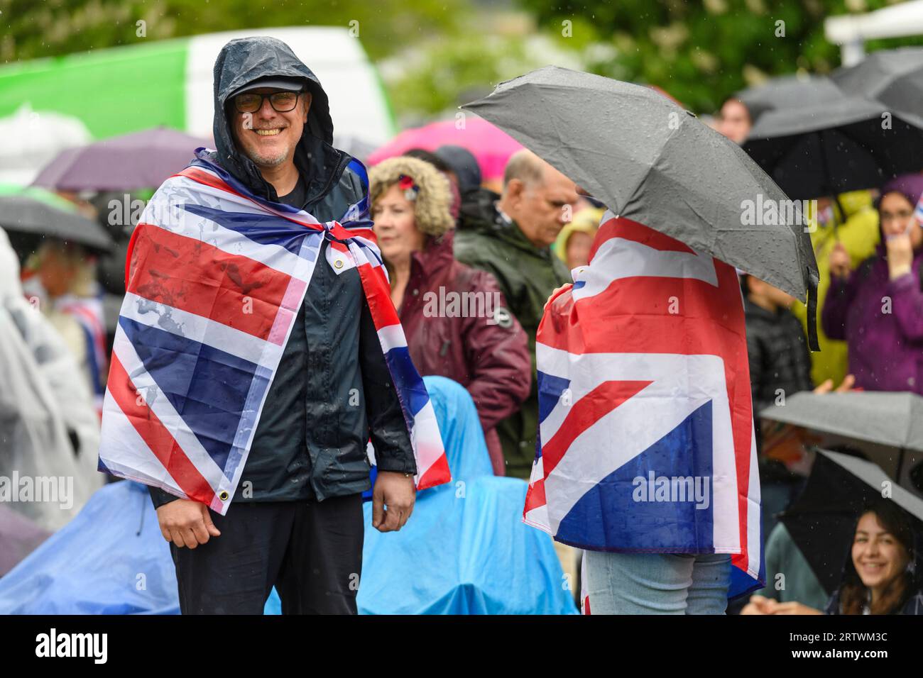 A couple with Union Jacks flags draped around their necks braving the ...