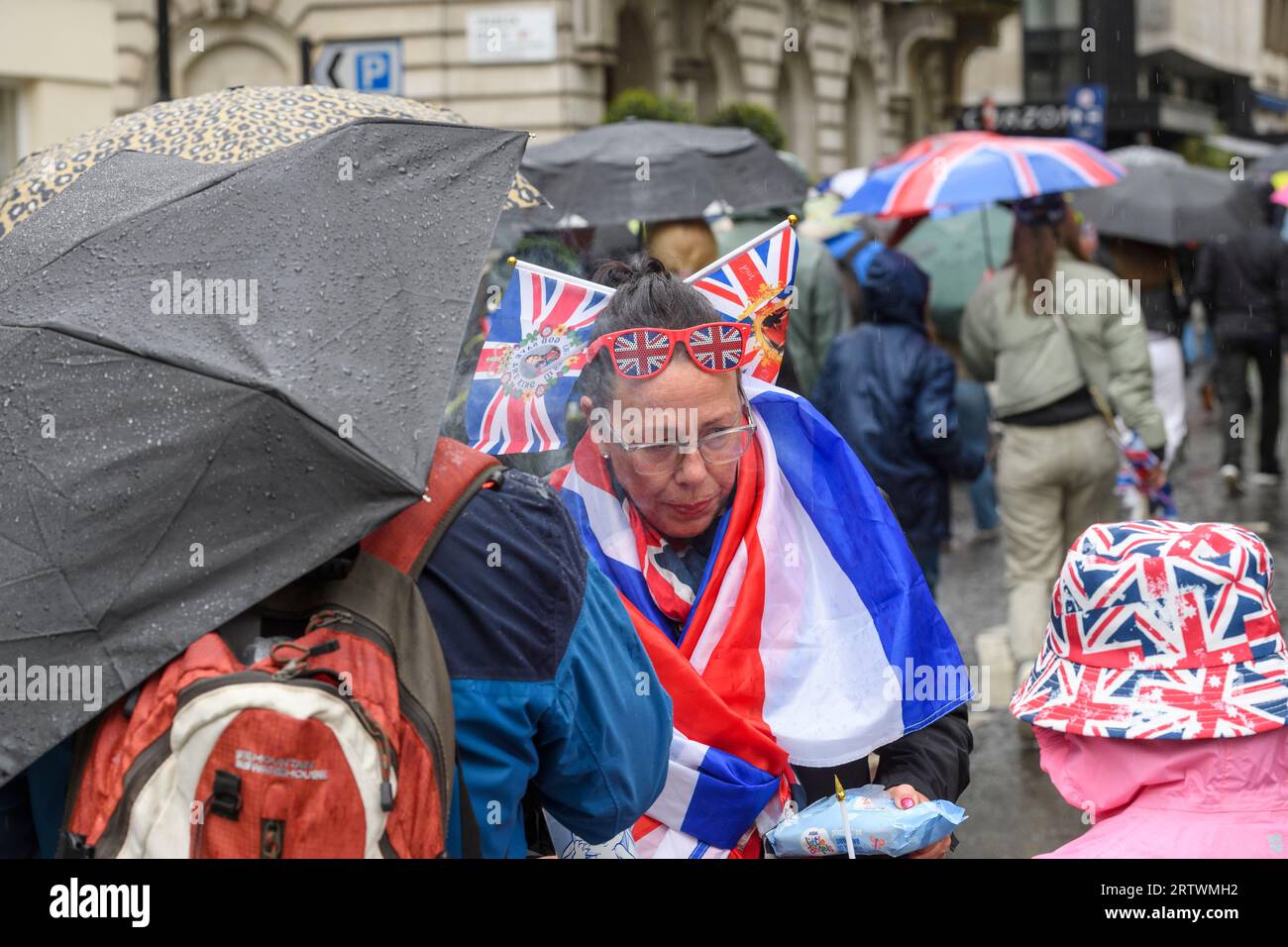 A woman with a Union Jack flag draped around her neck standing in ...