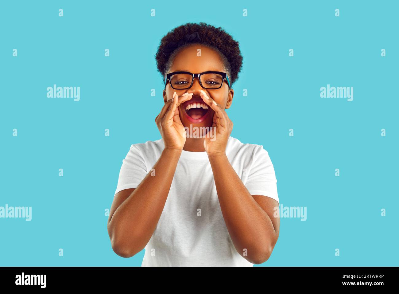 Funny Woman Holds Her Hands Near Her Open Mouth And Speaks Loudly Against Light Blue Background