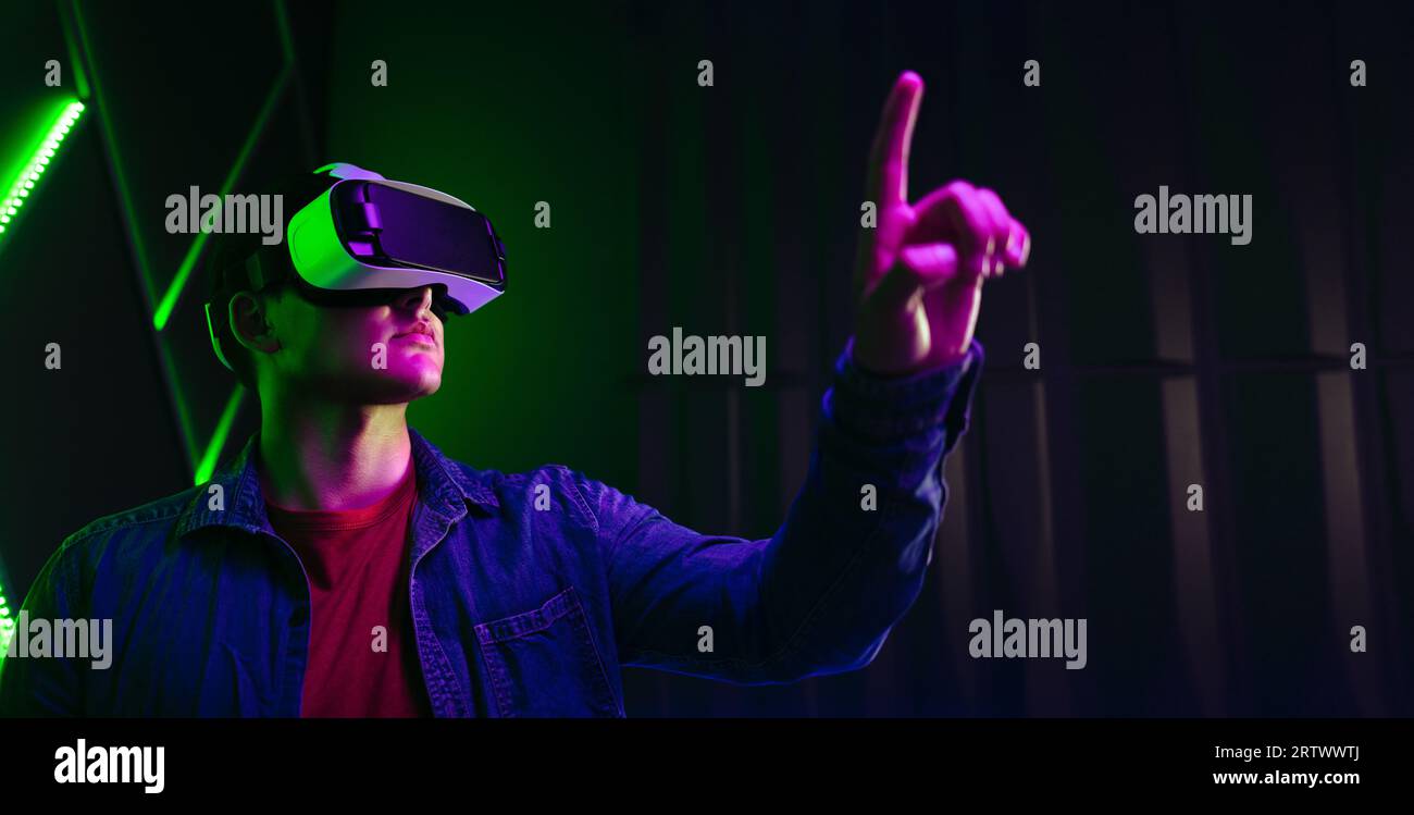 Man in his 20's wearing a VR headset, immersed in a virtual reality ...