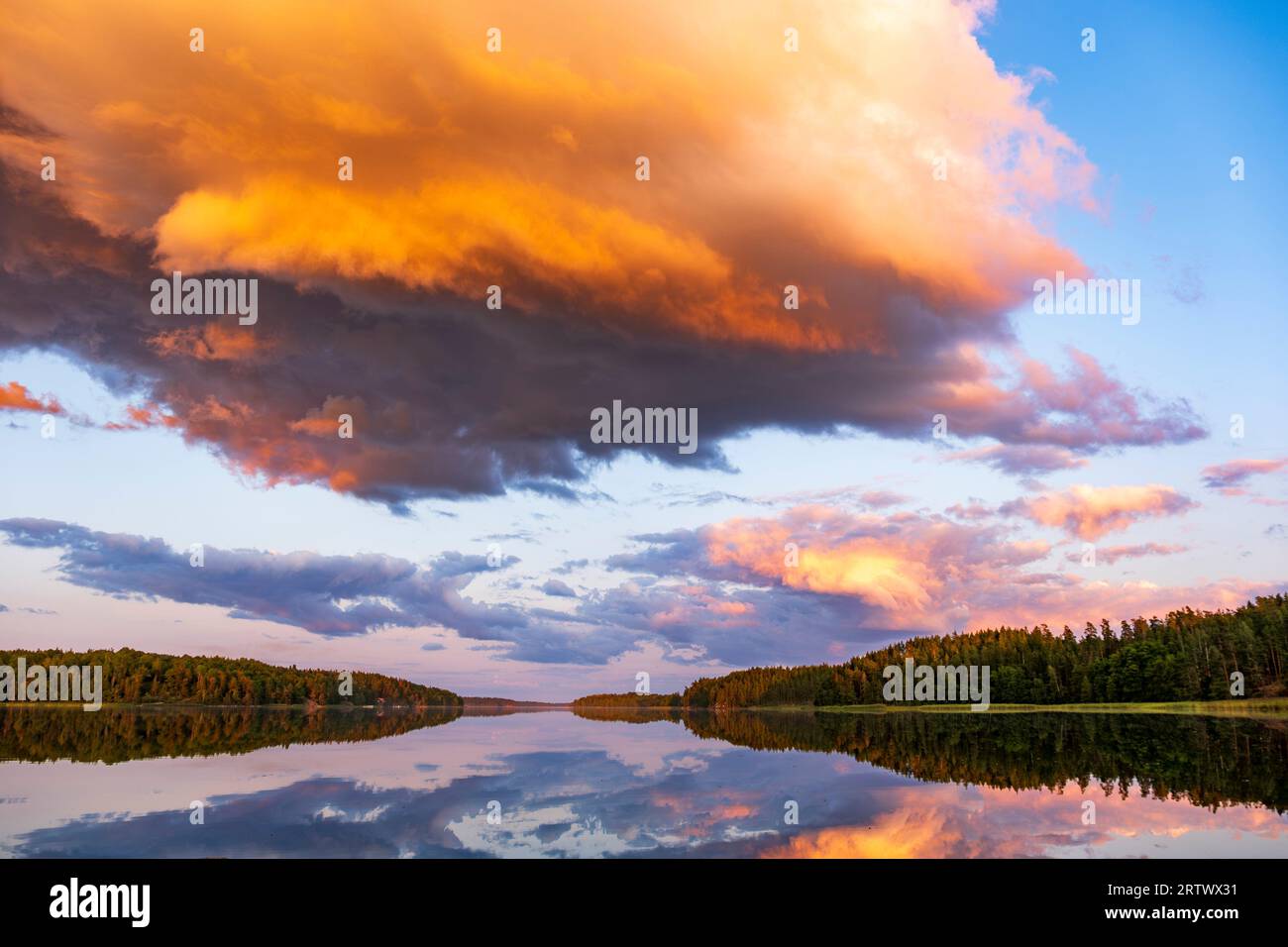 Giant sunset lit cloud over the landscape of St. Anna Archipelago with ...