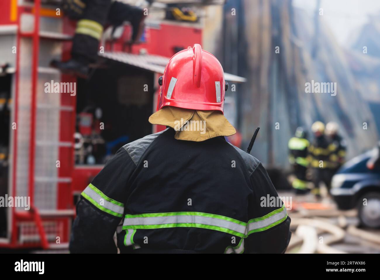 Group of fire men in protective uniform during fire fighting operation ...