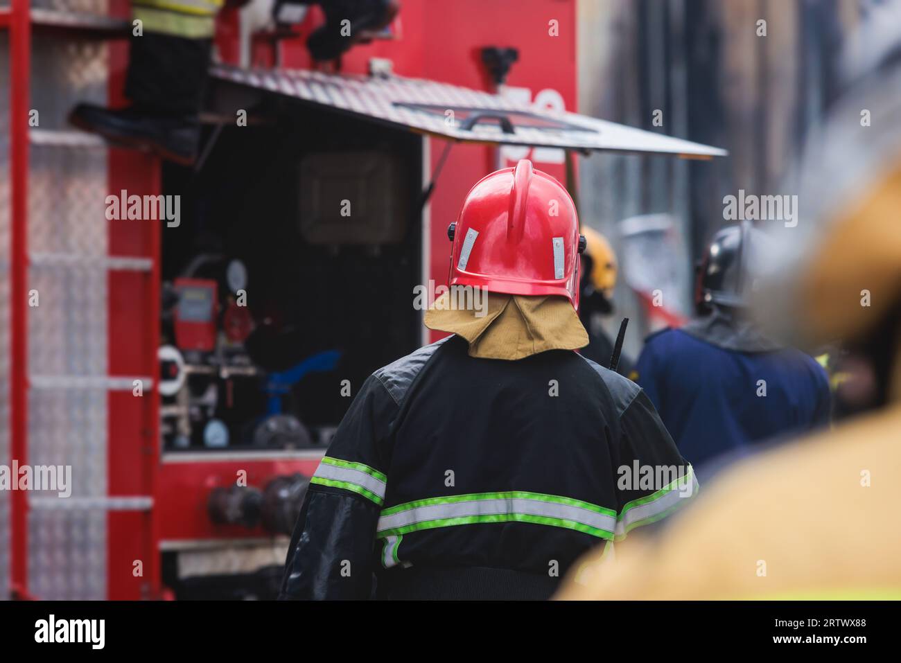 Group of fire men in protective uniform during fire fighting operation ...