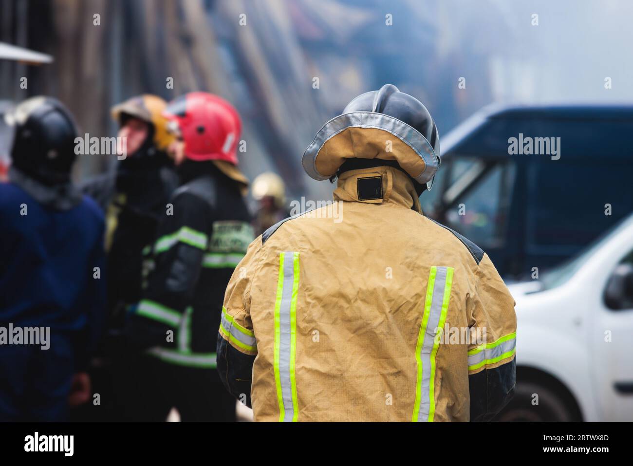 Group of fire men in protective uniform during fire fighting operation ...