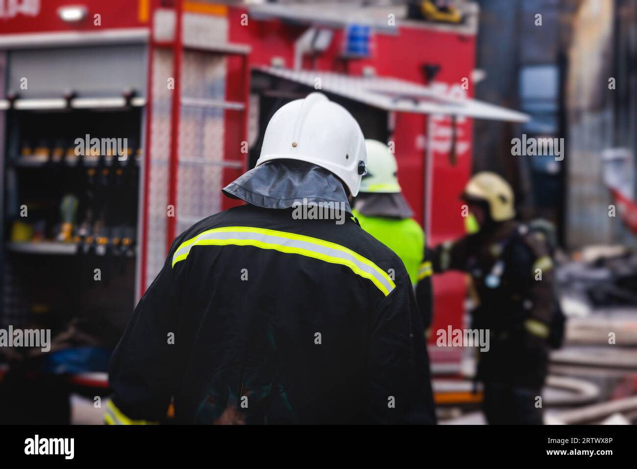 Group of fire men in protective uniform during fire fighting operation ...